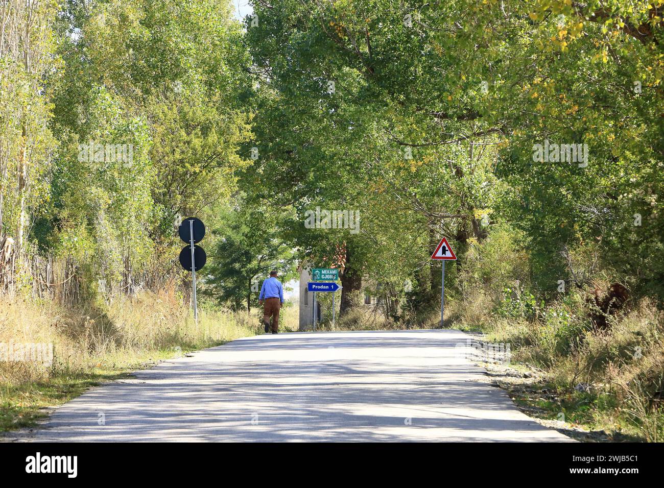 Old man walking alone on a road, albania Stock Photo - Alamy
