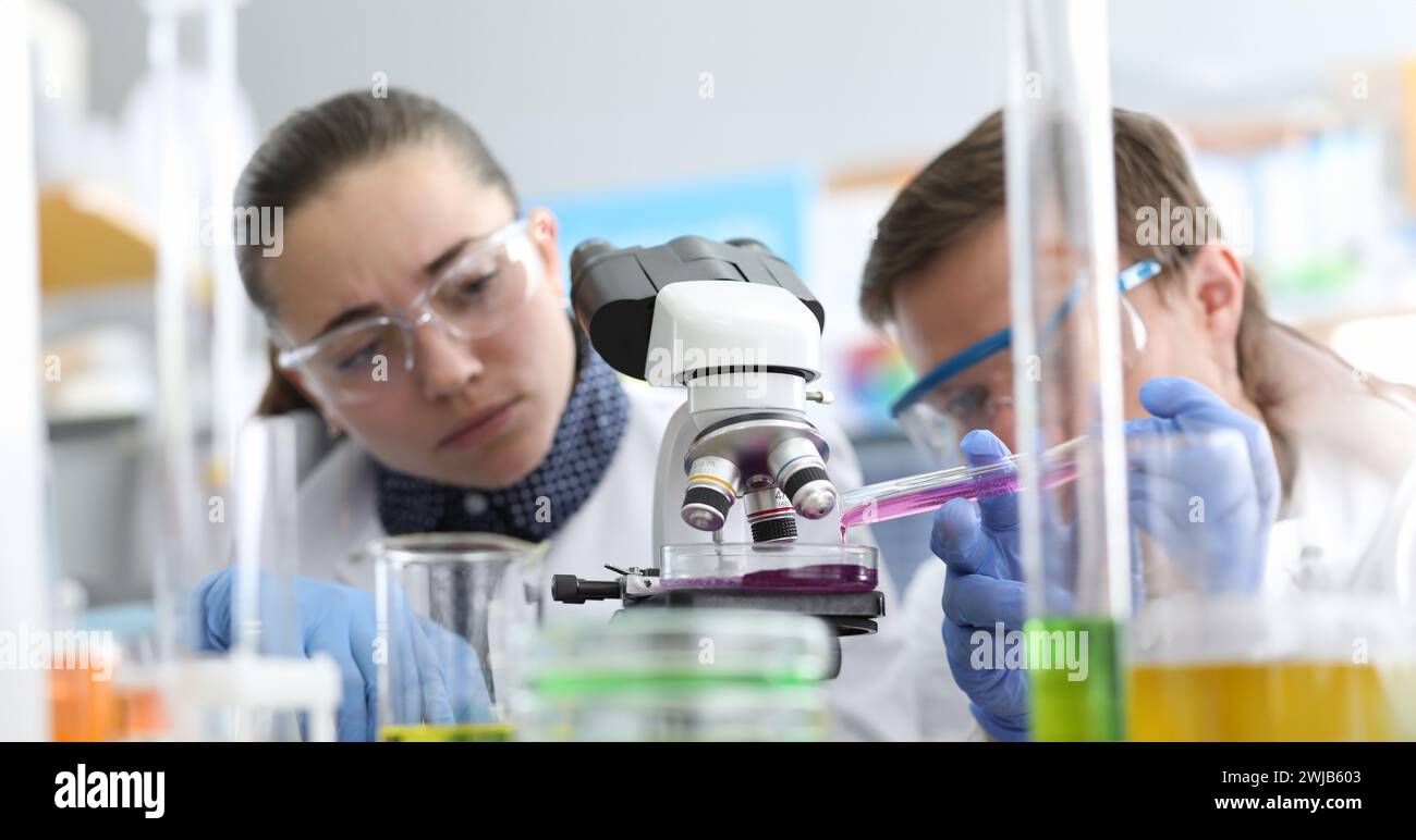 People look at reaction liquid under microscope Stock Photo - Alamy