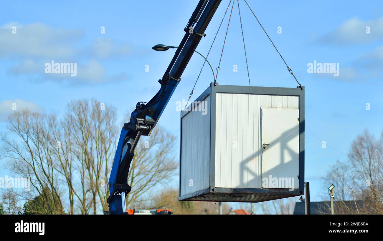 A crane transports a housing container to the construction site Stock ...