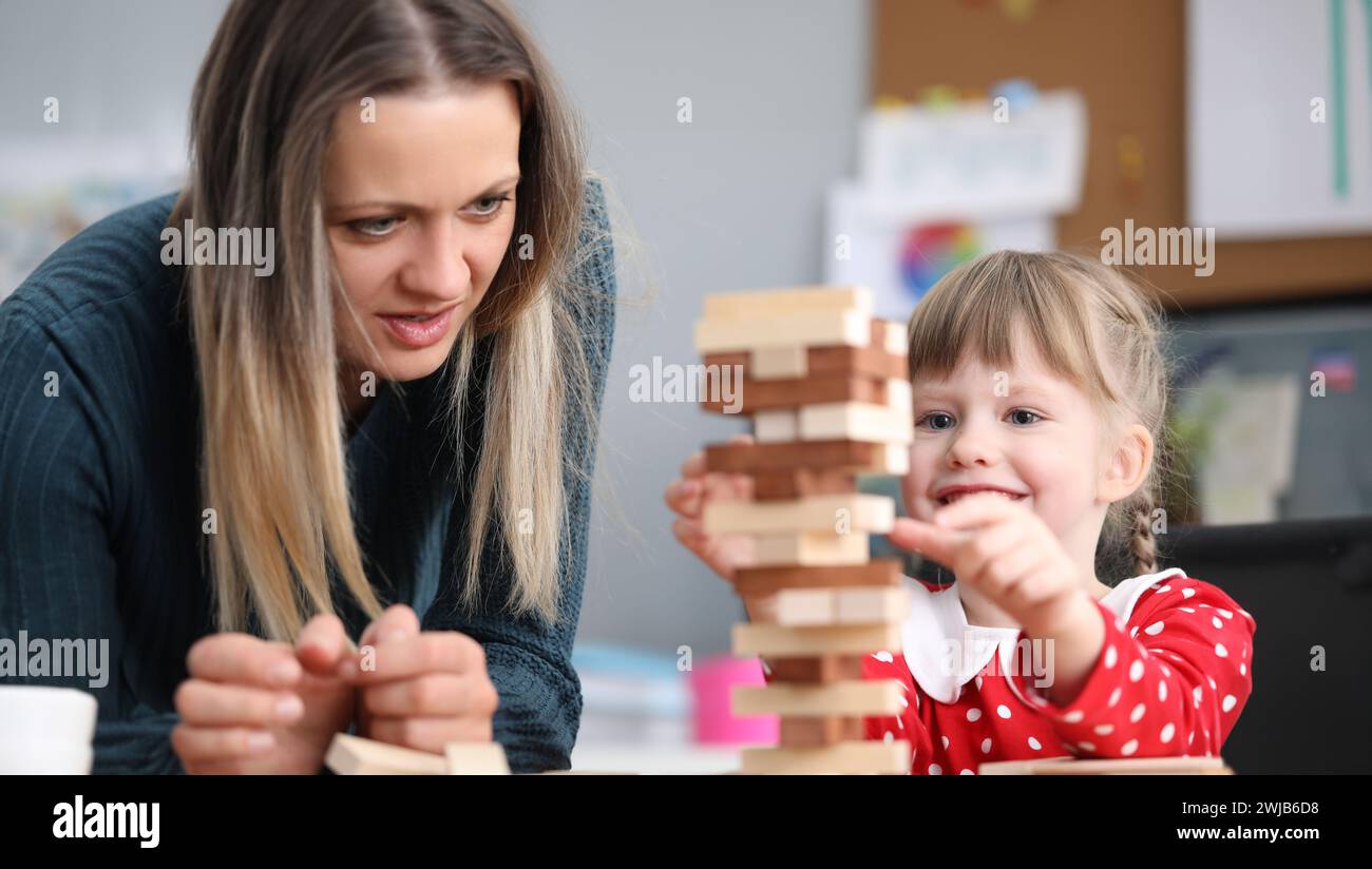 Mom and daughter stack blocks on top each other Stock Photo - Alamy