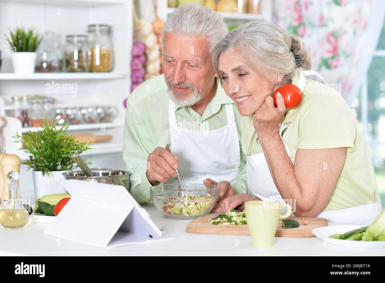 Portrait of a senior couple cooking in kitchen Stock Photo - Alamy