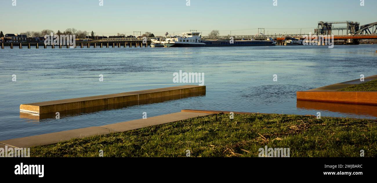 Super wide angle view of bench on the edge of high water level river ...