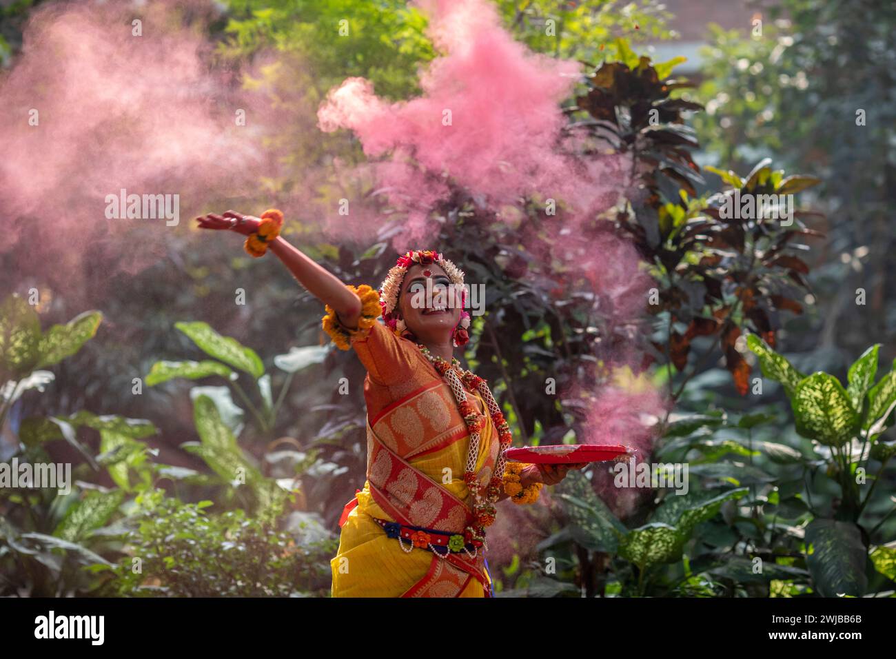 Dhaka, Bangladesh. 14th Feb, 2024. A woman seen blowing colour powder ...