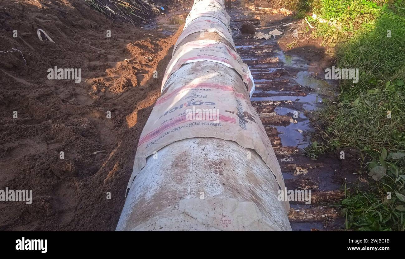 Laying sewer Concrete drainage pipe between large residential areas ...