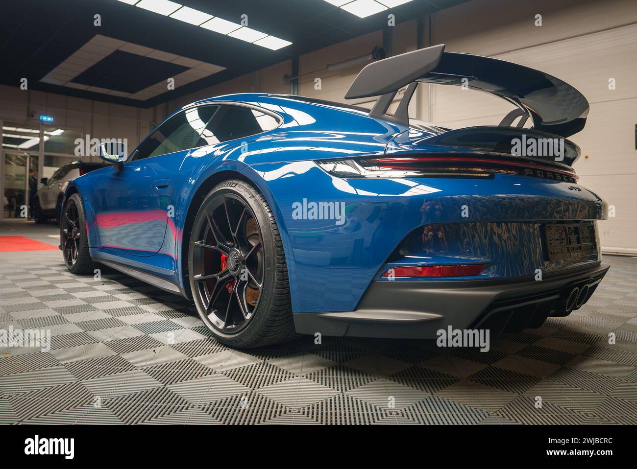 Blue Porsche 911 GT3, featuring a Rear Wing, showcased in a Showroom ...