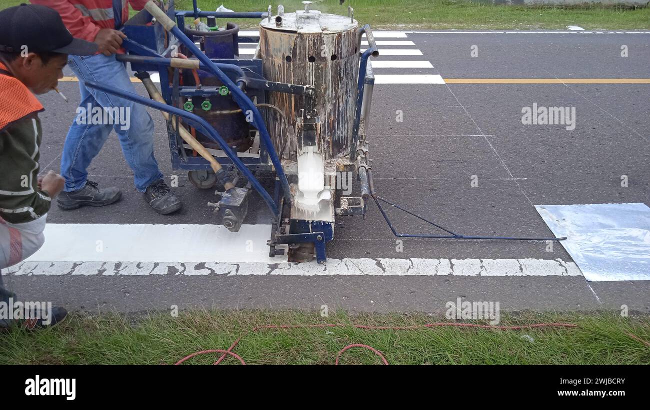 Low section of Road Worker using Thermoplastic Marking Machine to ...