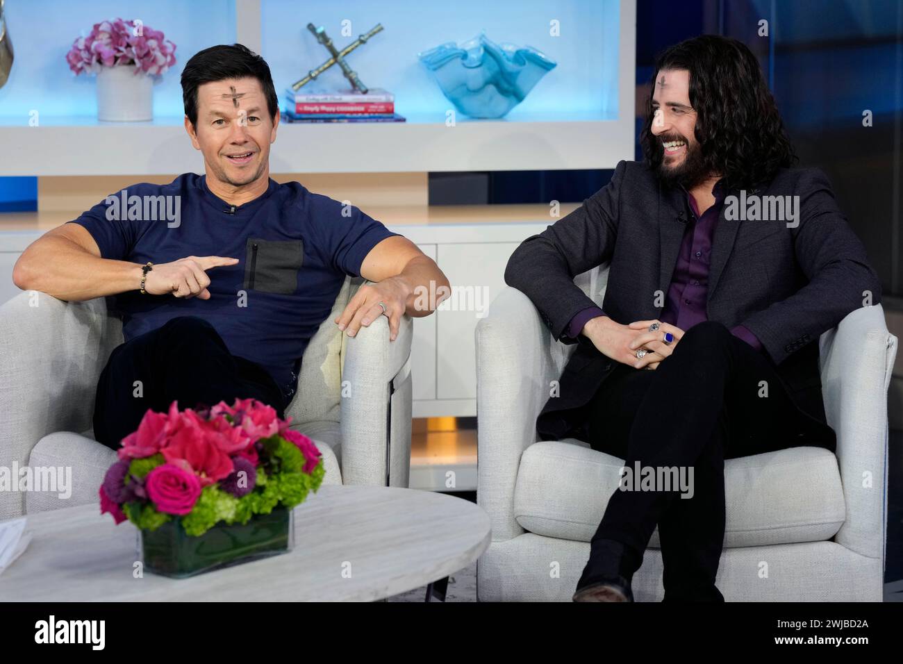 Mark Wahlberg, left, and Jonathan Roumie bear a cross of ashes on their ...