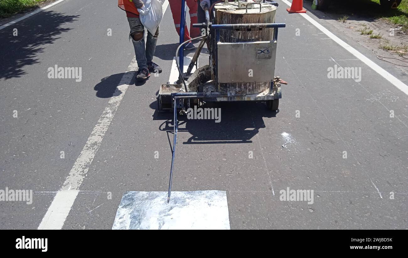 Low section of Road Worker using Thermoplastic Marking Machine to ...