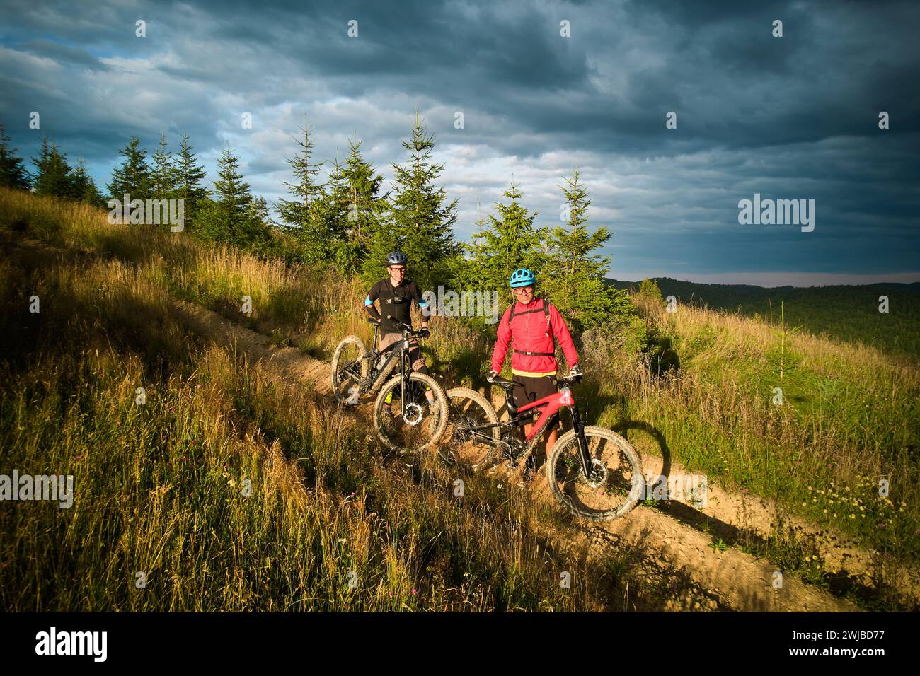Two cyclists men riding electric bikes outdoors. Portrait of male ...