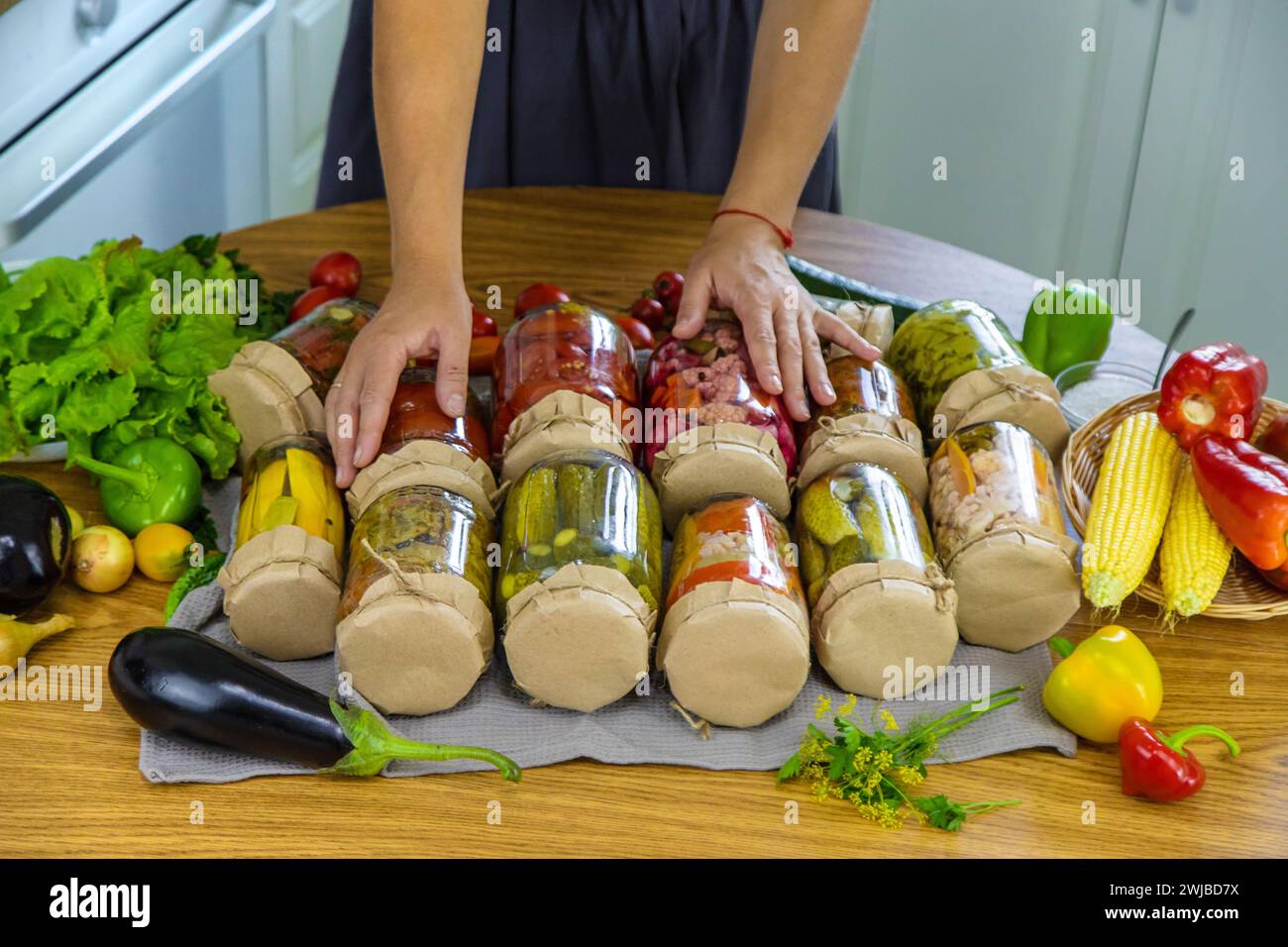 Woman canning vegetables in jars in the kitchen. Selective focus Stock ...