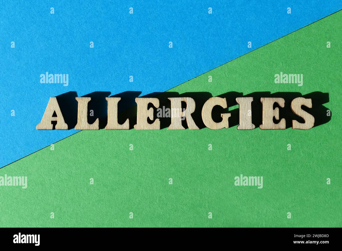 Allergies, word in wooden alphabet letters isolated on green and blue ...