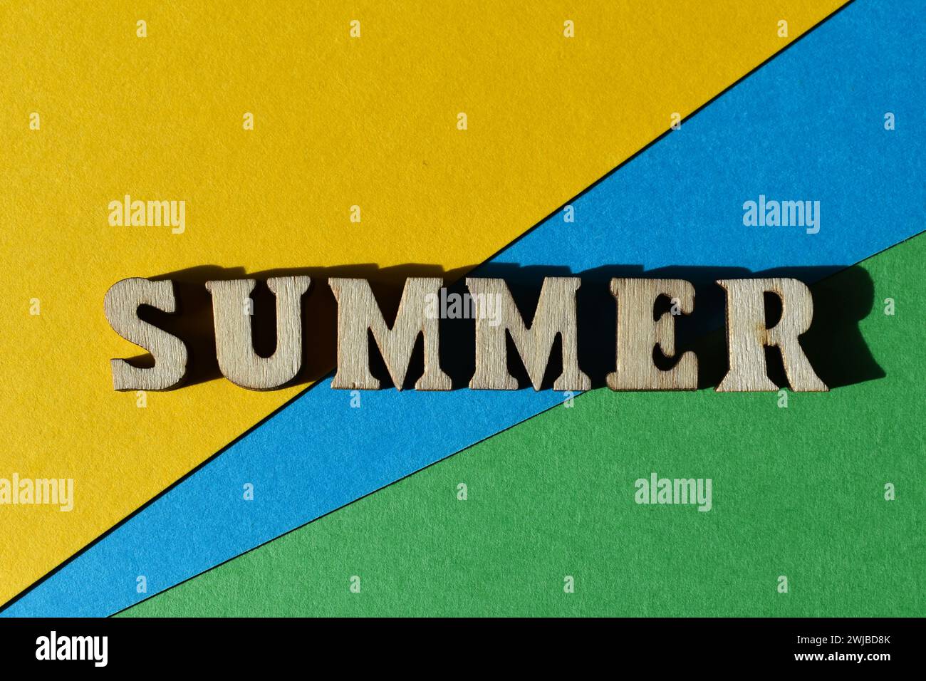 Summer, word in wooden alphabet letters isolated on blue, green and ...