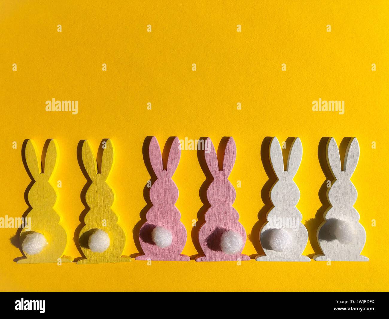 Easter bunny rabbits isolated on yellow background with copy space ...