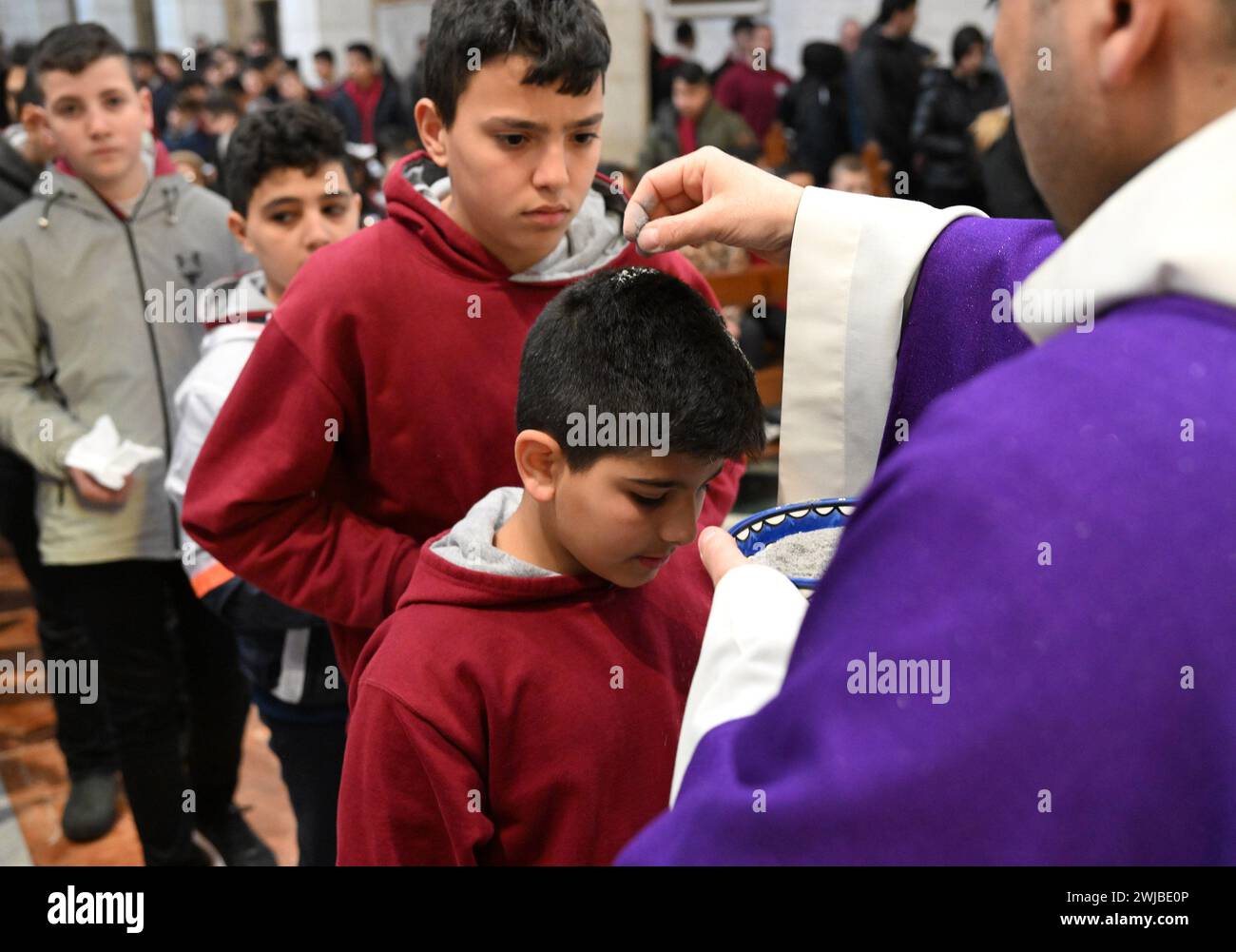 Bethlehem, West Bank. 14th Feb, 2024. Palestinian Catholic boys receive ashes on their heads ...
