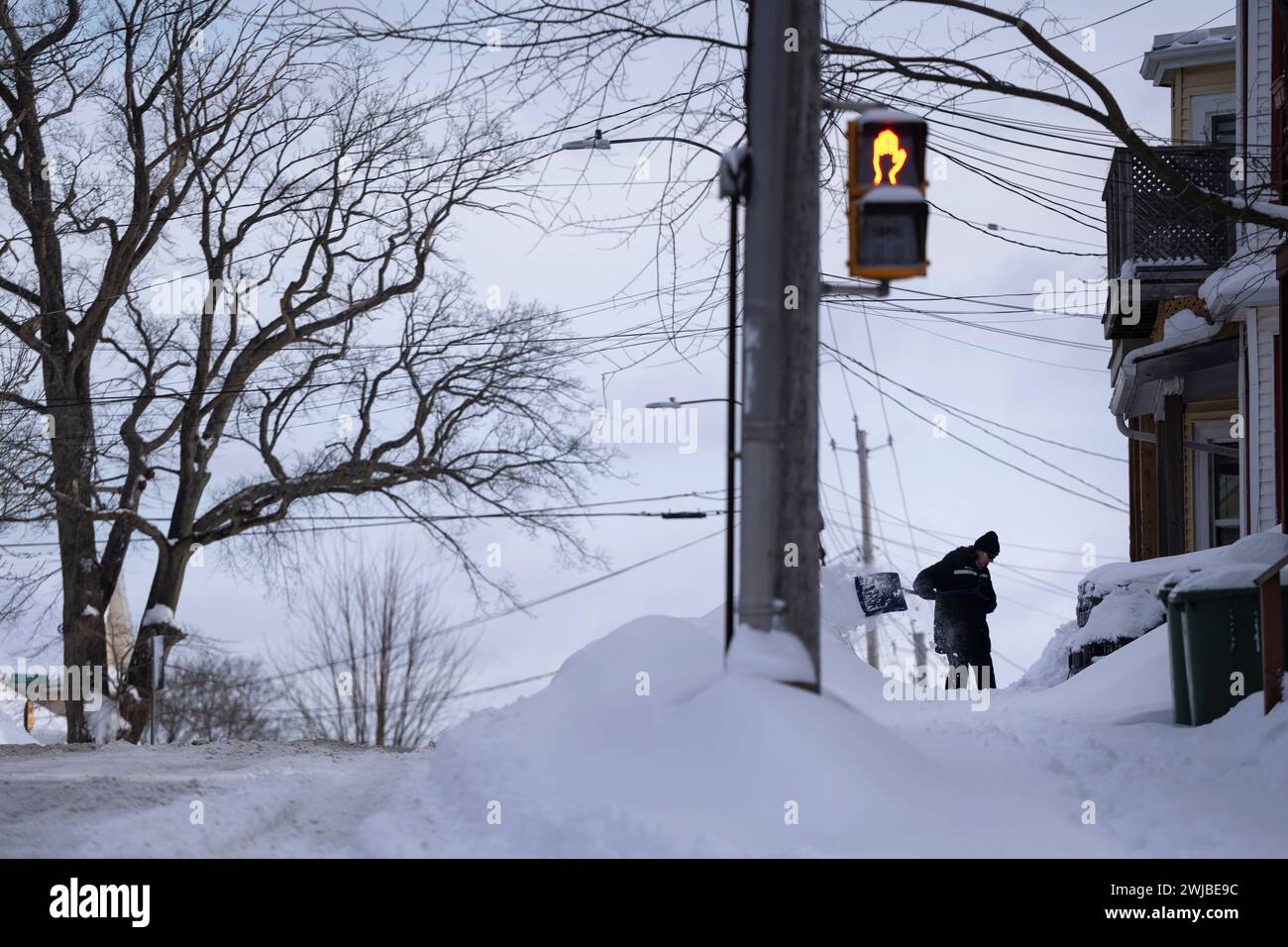 Halifax, Canada. 14th Feb, 2024. A person shovels their walkway ...