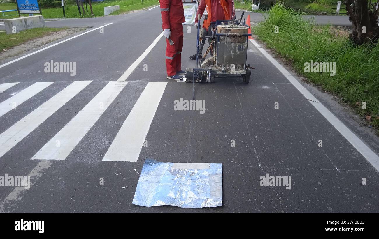 Road workers use hot-melt scribing machines to painting pedestrian ...