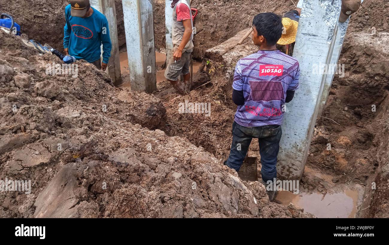 Deep foundation concrete pilings partially hammered into the ground ...