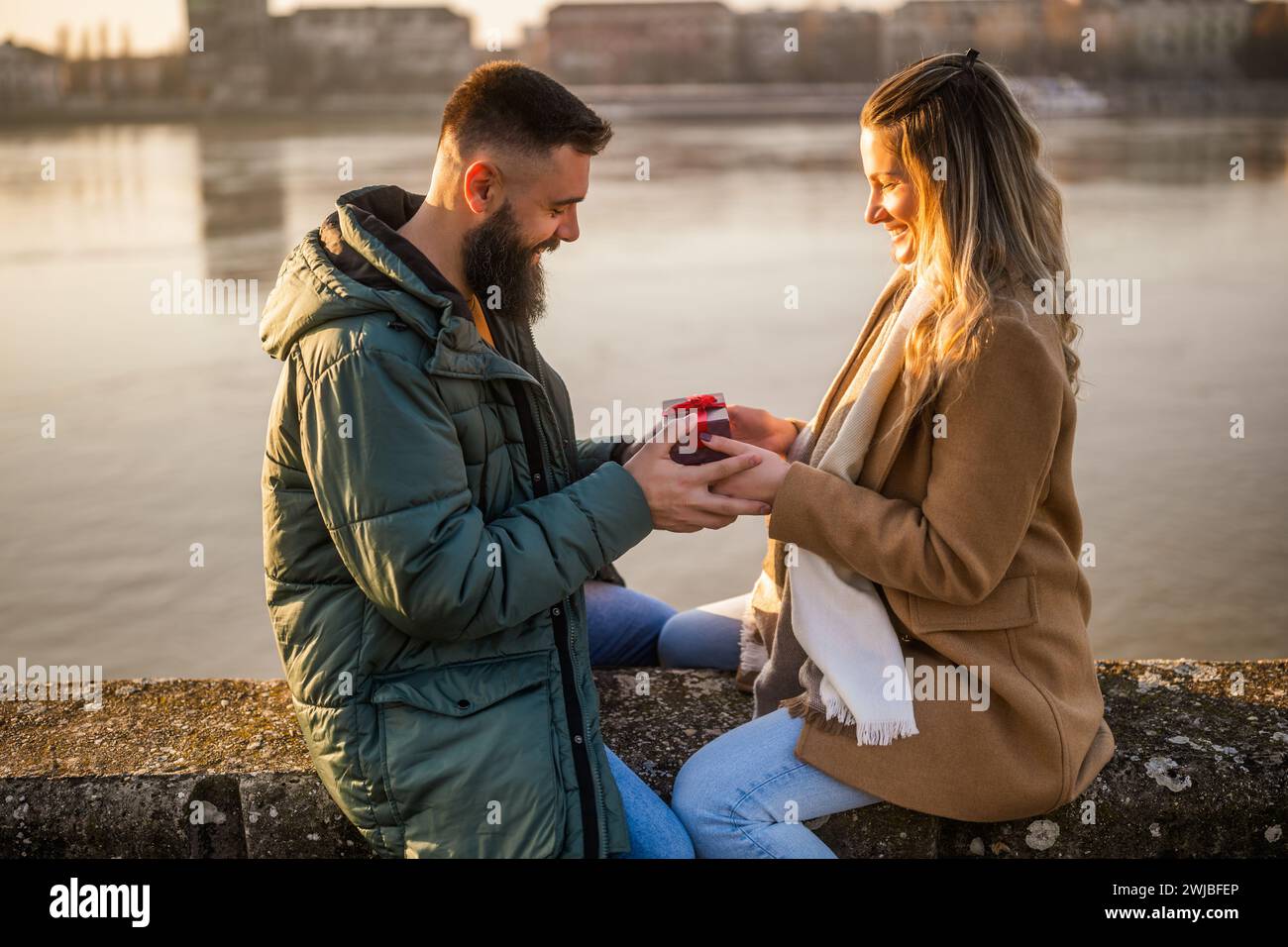 Woman giving presents to her man while they enjoy spending time ...