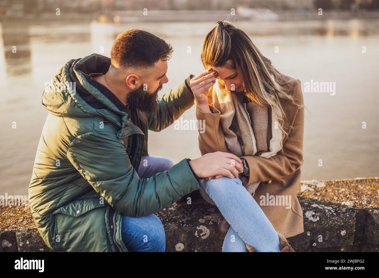 Couple having conflict and man is trying to comfort his sad and angry ...