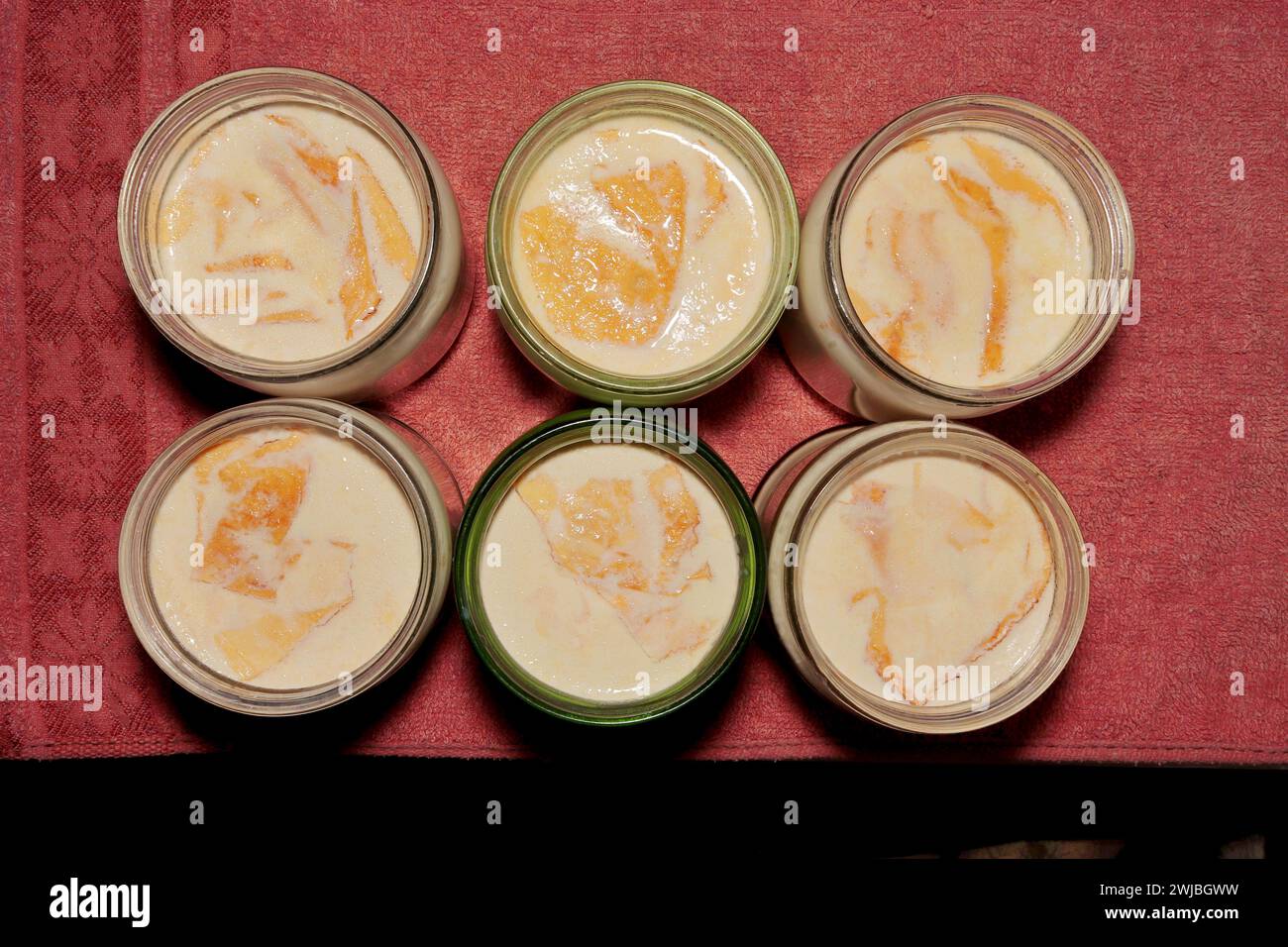 Jars with homemade fermented baked milk on the table top view Stock ...