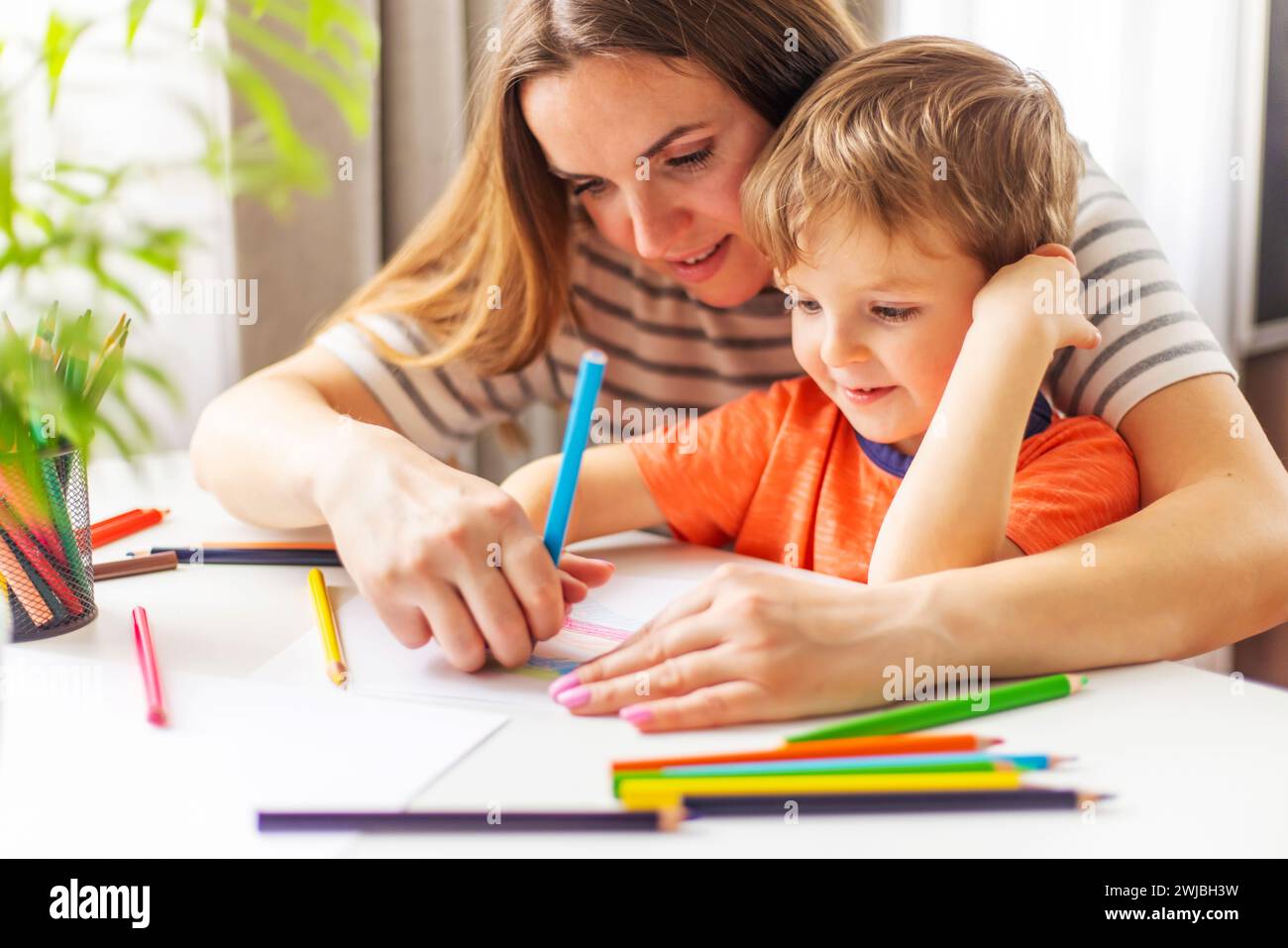 Mother Helping Child with Drawing at Home Stock Photo - Alamy