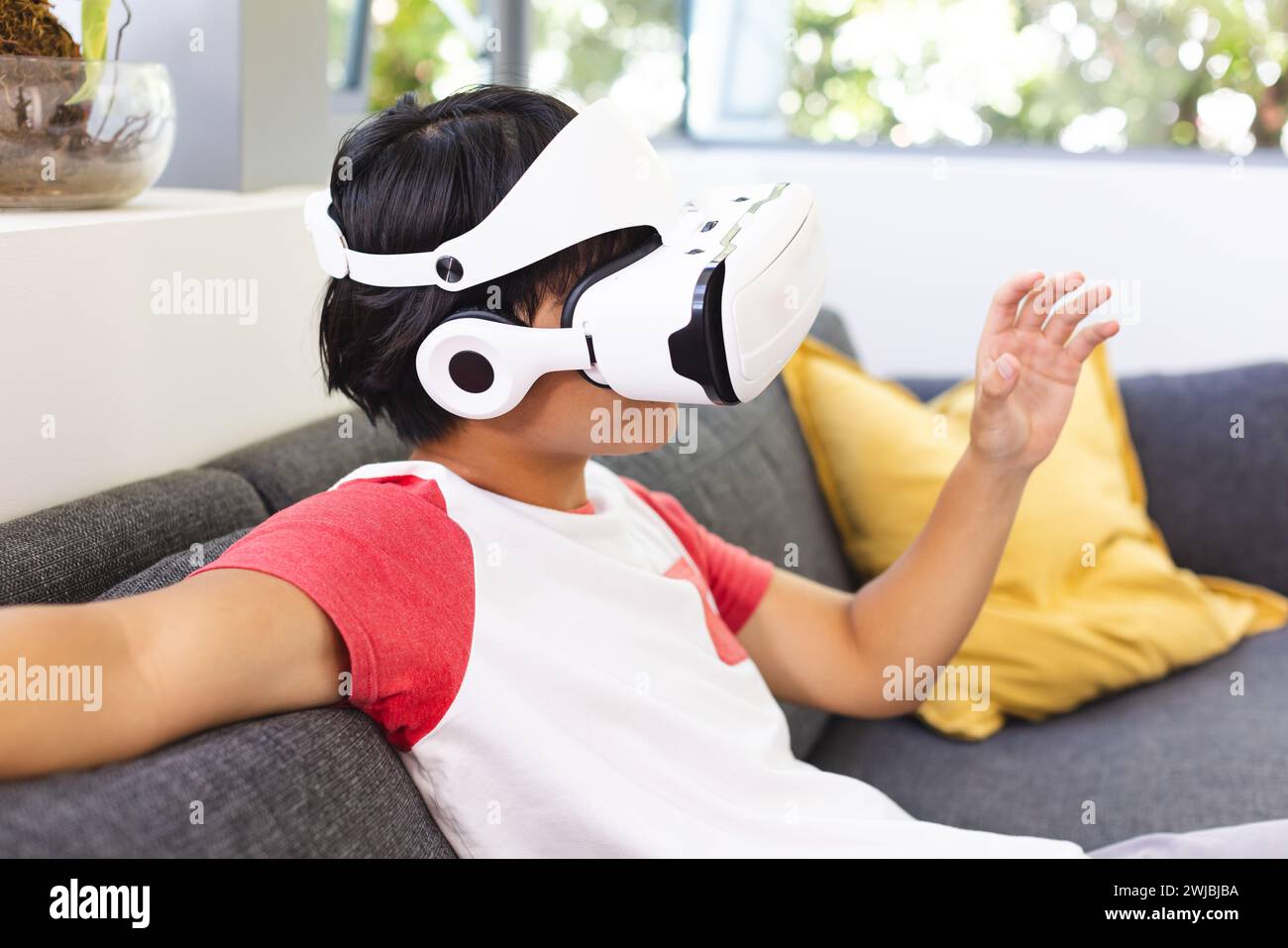 Teenage Asian boy explores virtual reality at home, with copy space ...