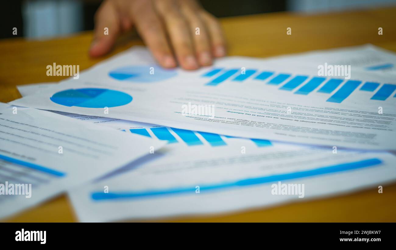 Business people analyzing charts information on documents, using papers ...