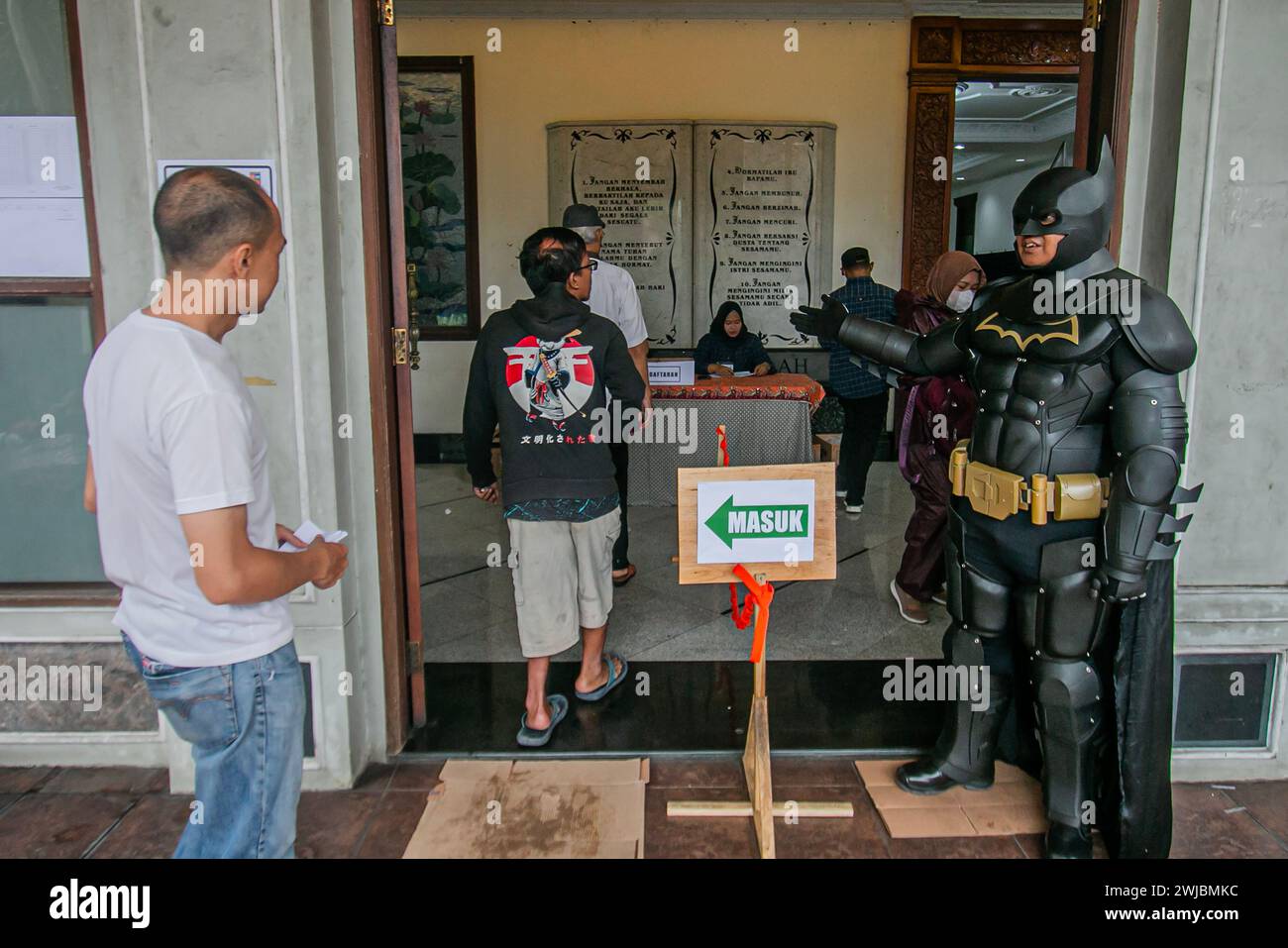 Bogor, Indonesia. 14th Feb, 2024. An election official wearing Batman ...