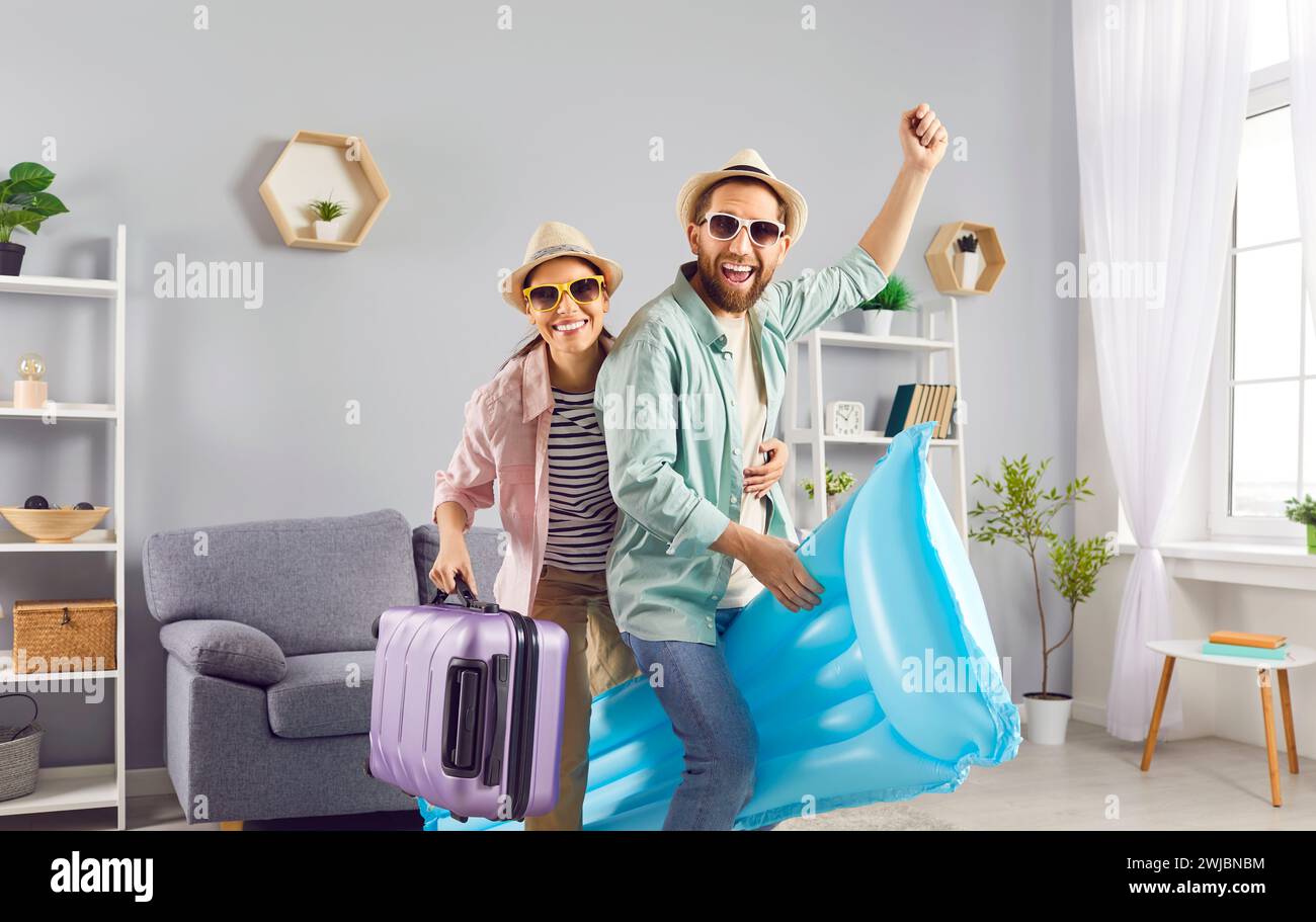 Happy young couple having fun ready for summer holiday trip standing at ...