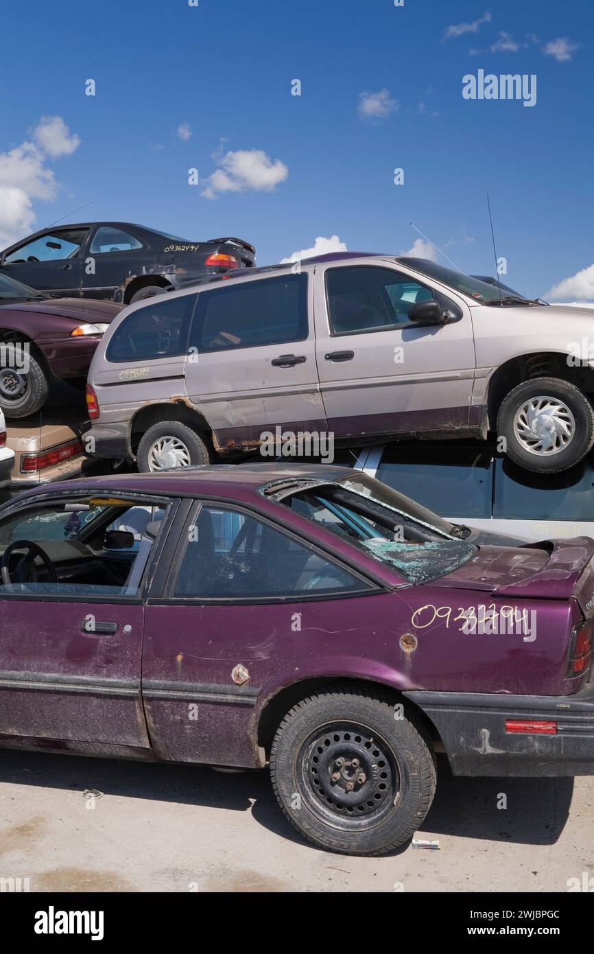 Stacked automobiles and mini van at scrap metal recycling junkyard ...