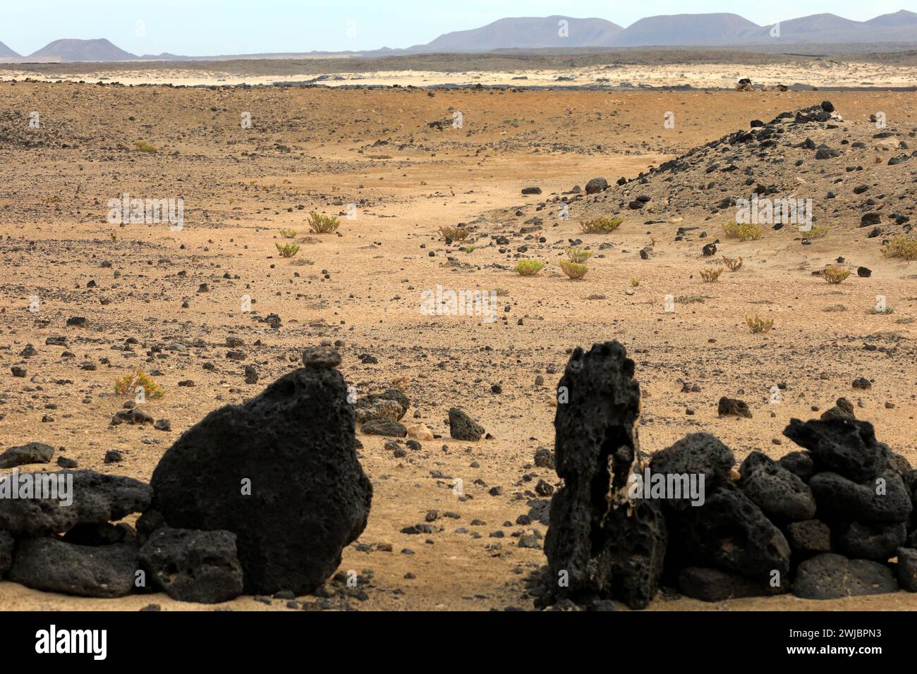 Black volcanic wall with gateway and path leading into the distance ...