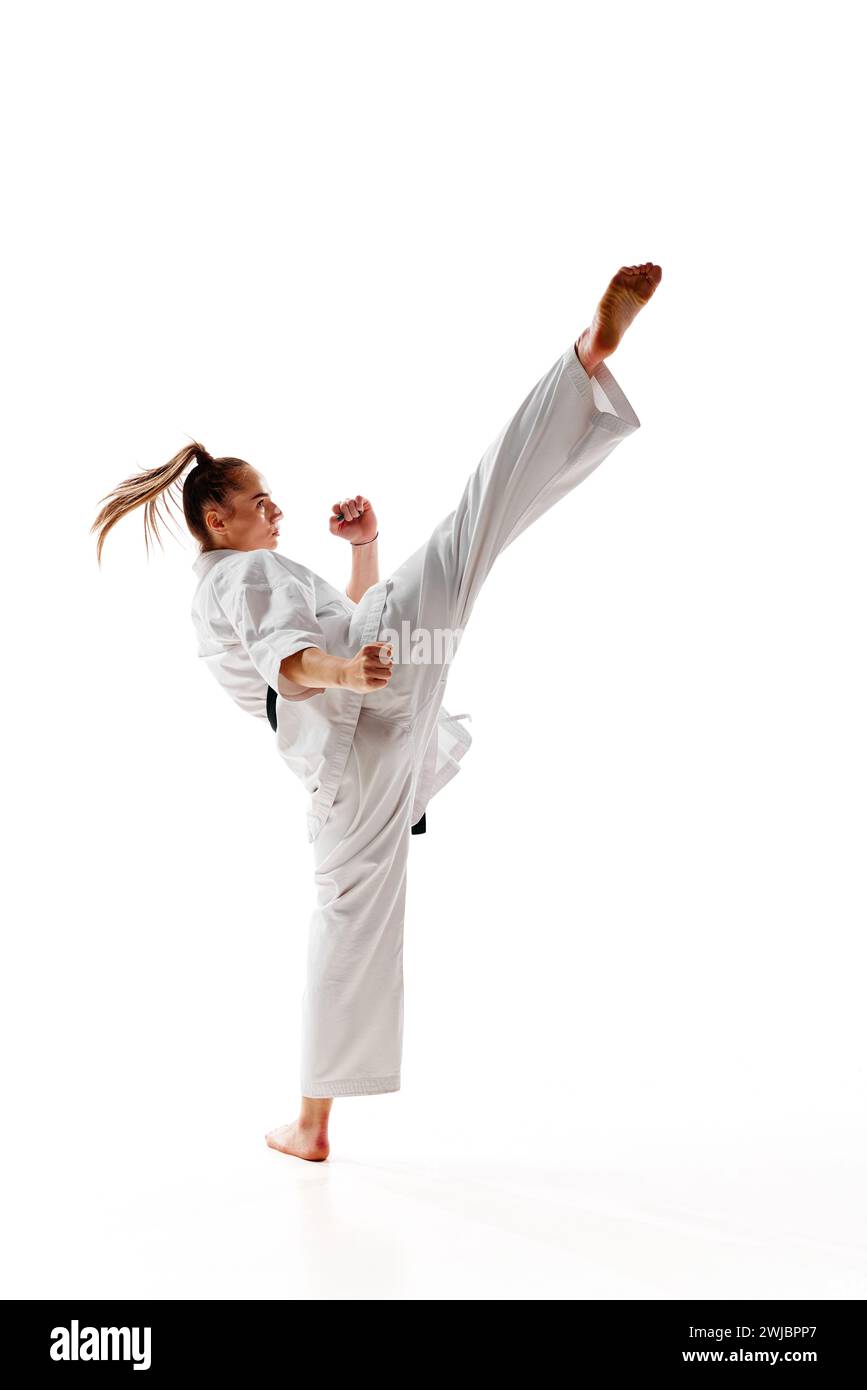 Rear view. Woman professional karate fighter performing kick in action ...