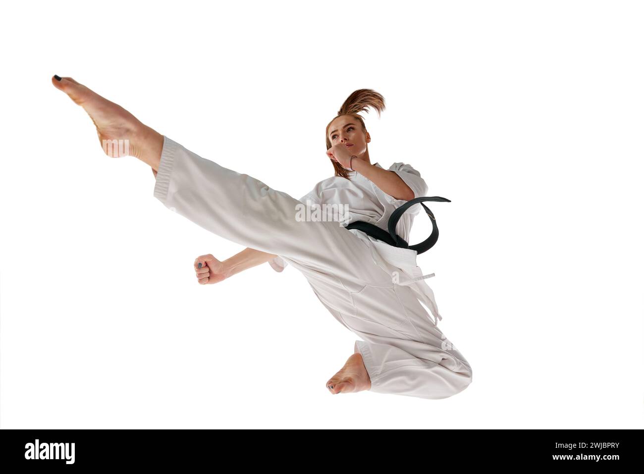 Rear view. Woman professional karate fighter jumping and performing ...