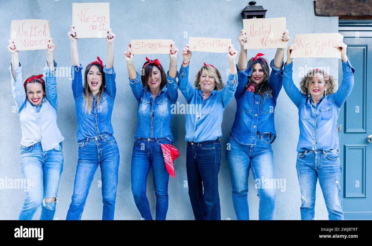 A group of exuberant women in denim, with red bandanas, cheerfully ...