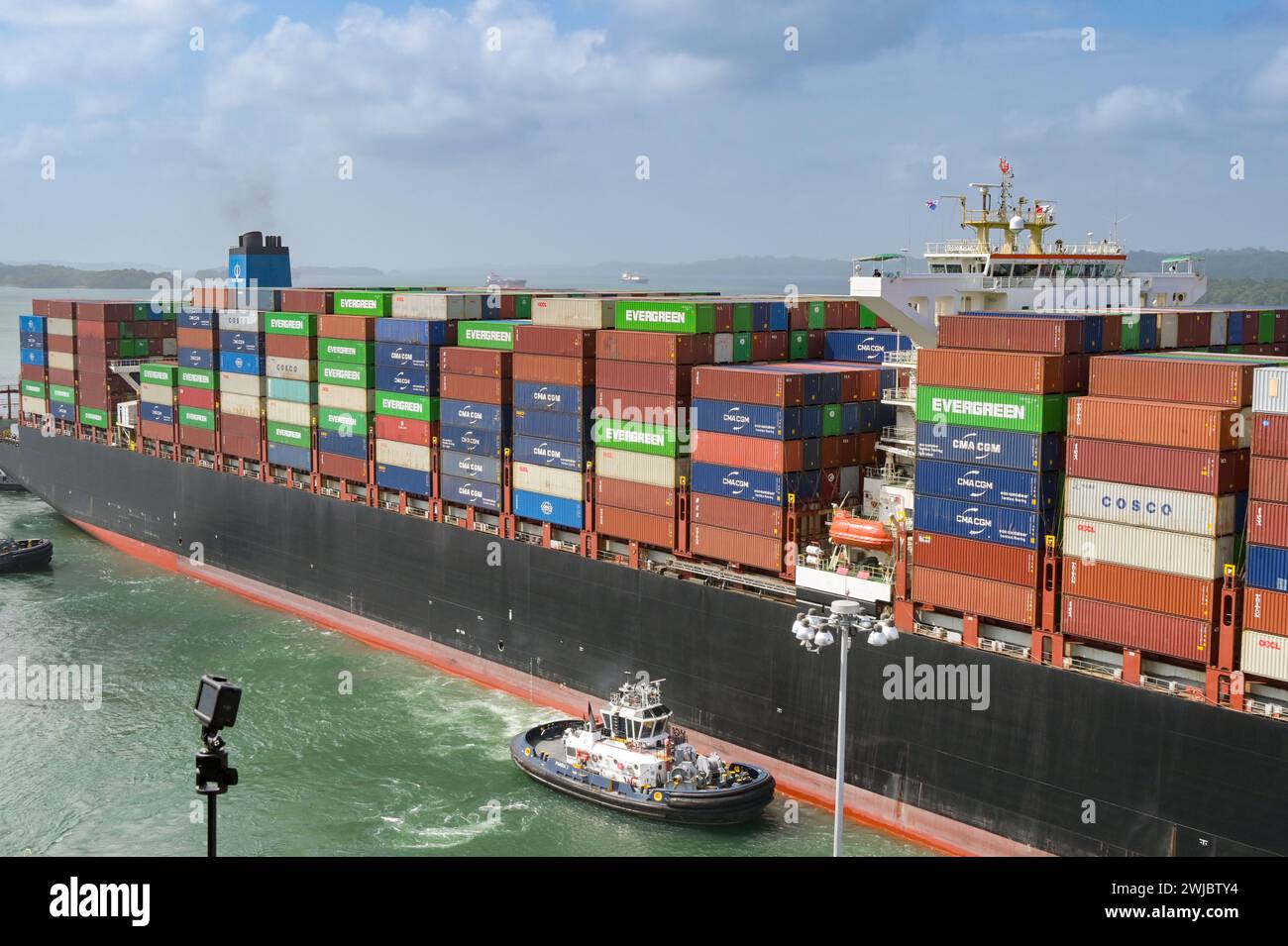 Colon, Panama - 22 January 2024: Tug boat assiting a large container ...