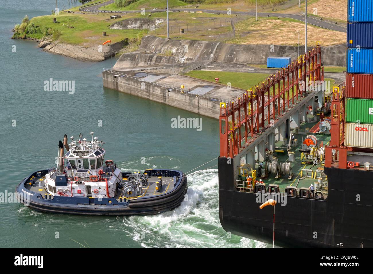 Colon, Panama - 22 January 2024: Tug boat assiting a large container ...