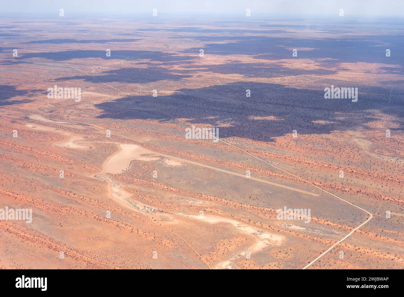 aerial landscape with little airfiled sand runway and red dune stripes ...