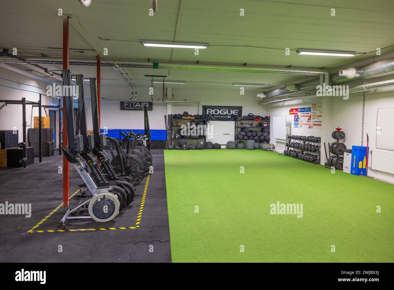 Equipped gym featuring various strength machines and sandbags ...