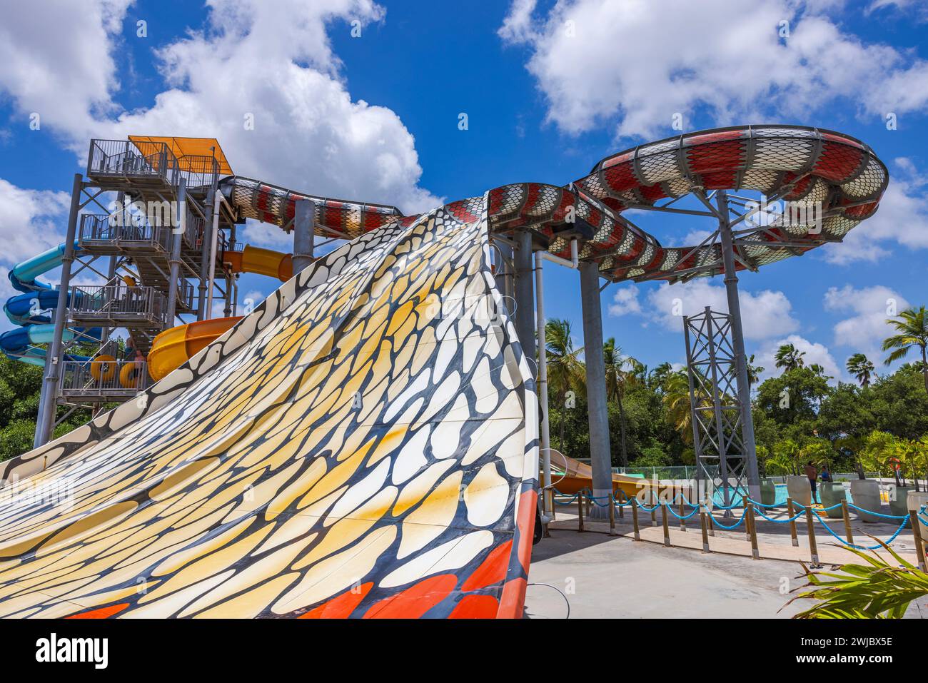 View of a beautiful water slide with a cobra-scale pattern on blue sky ...