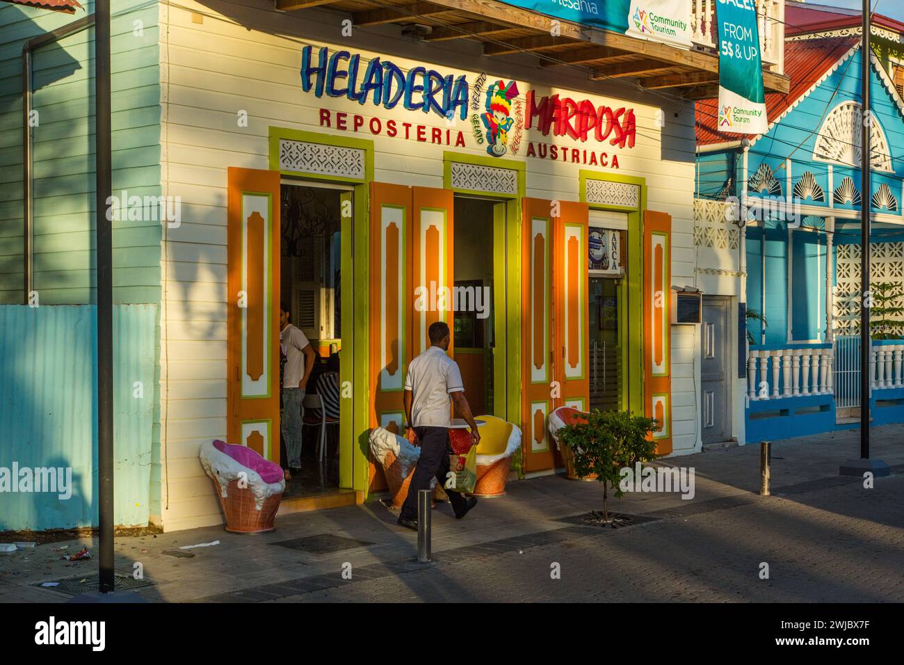 A colorful painted ice cream shop in a Victorian building facing ...