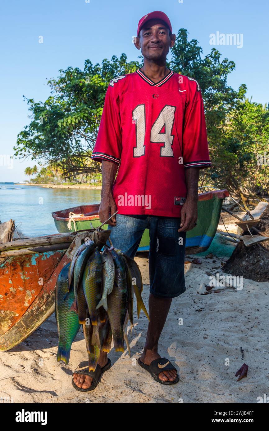 A Dominican fisherman with his catch at the beach at Bahia de Las ...