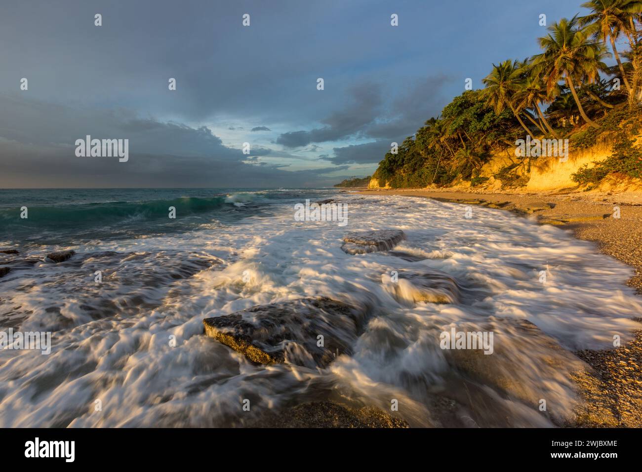 Waves breaking on the rocks at sunrise on a beach near Barahona ...