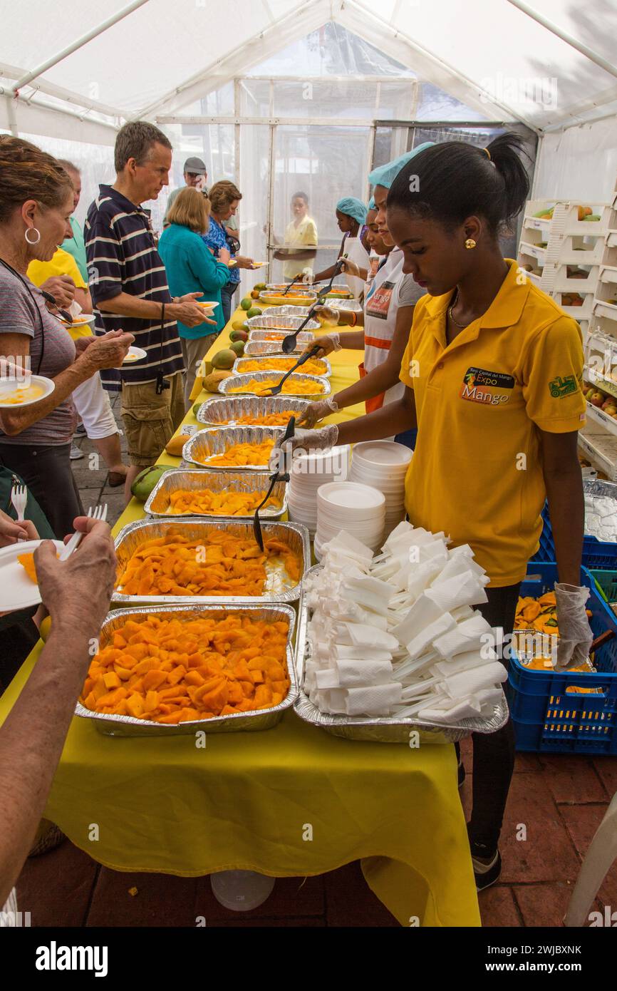 Tourists at the mango tasting booth, trying different varieties of ...