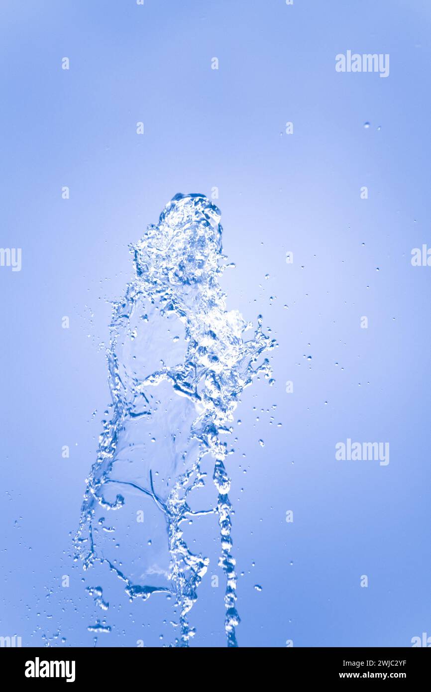 dynamic splash of clear blue water captured in mid-air against a serene ...