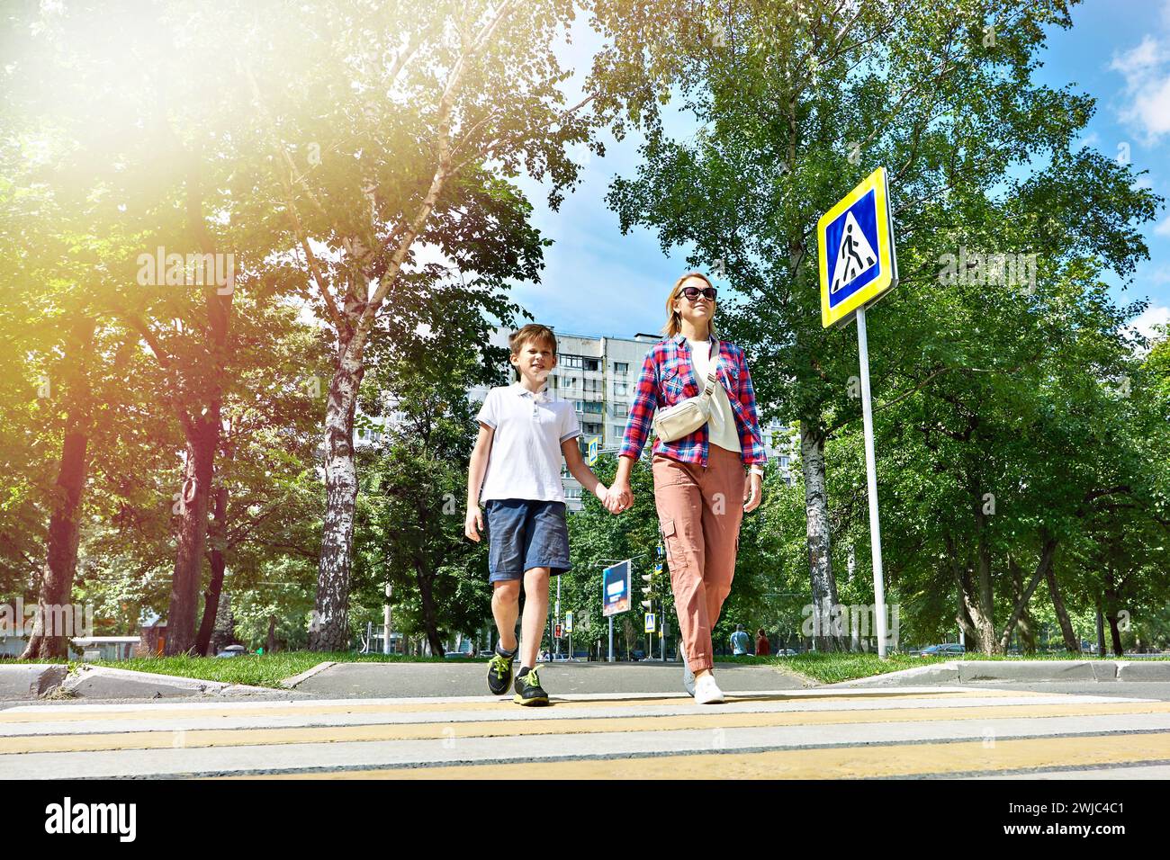 Mother and child walk on pedestrian crossing Stock Photo - Alamy