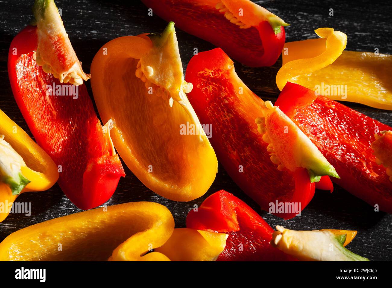 sliced bell pepper mix on black wood background Stock Photo - Alamy