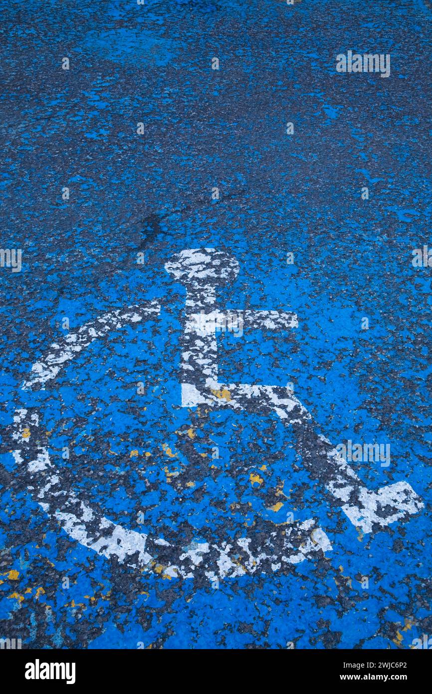 Handicap wheelchair parking pictogram sign on blue painted asphalt ...