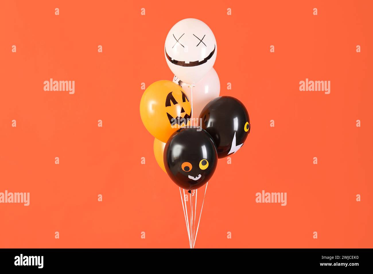 Different creepy Halloween balloons on orange background Stock Photo ...