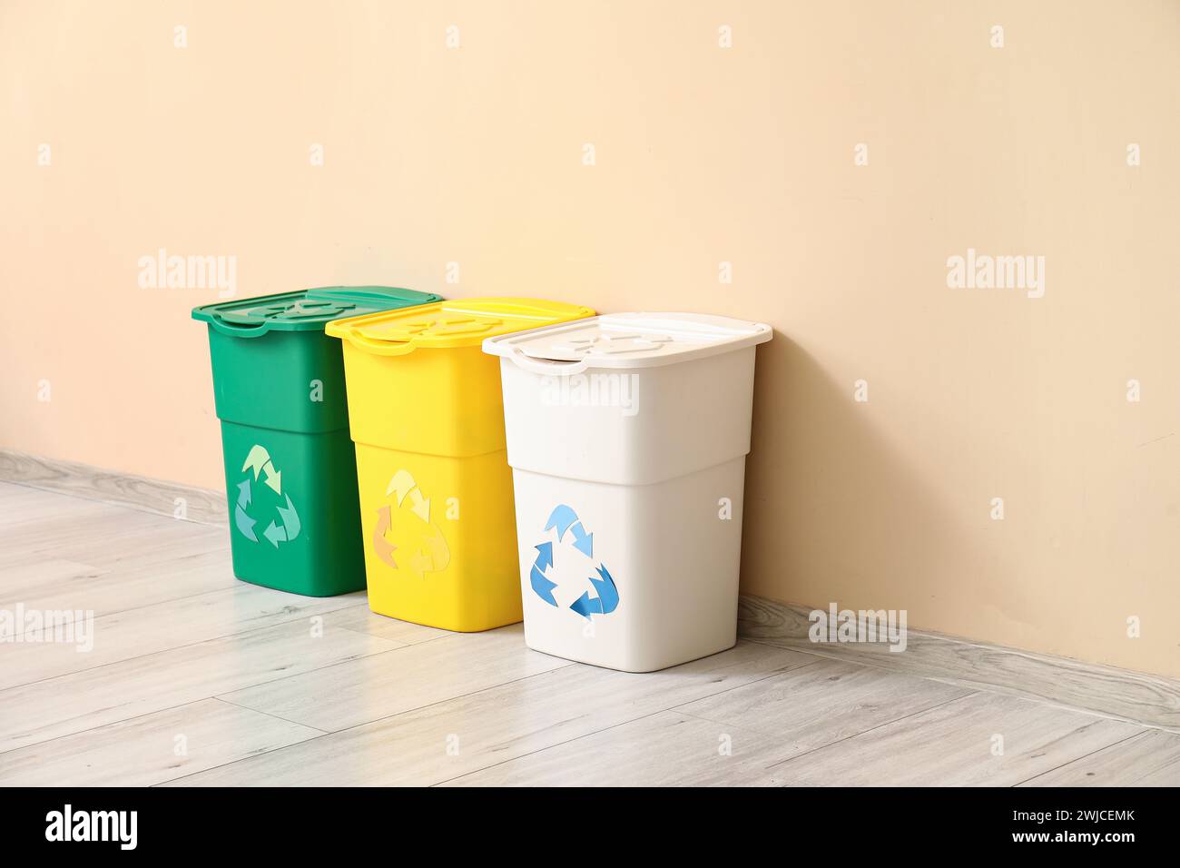Containers for garbage near beige wall. Recycling concept Stock Photo ...