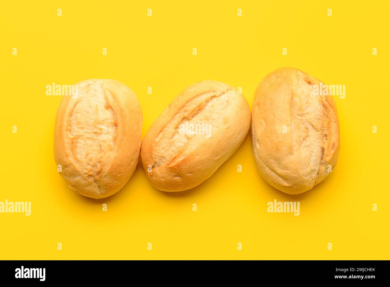 Fresh delicious buns on yellow background Stock Photo - Alamy